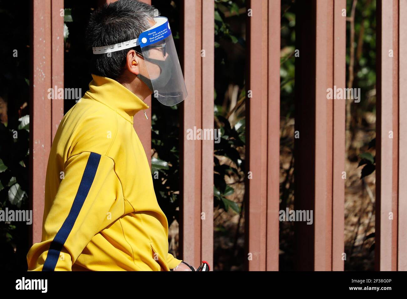 A man wearing a face shield as a precaution against the spread of covid ...