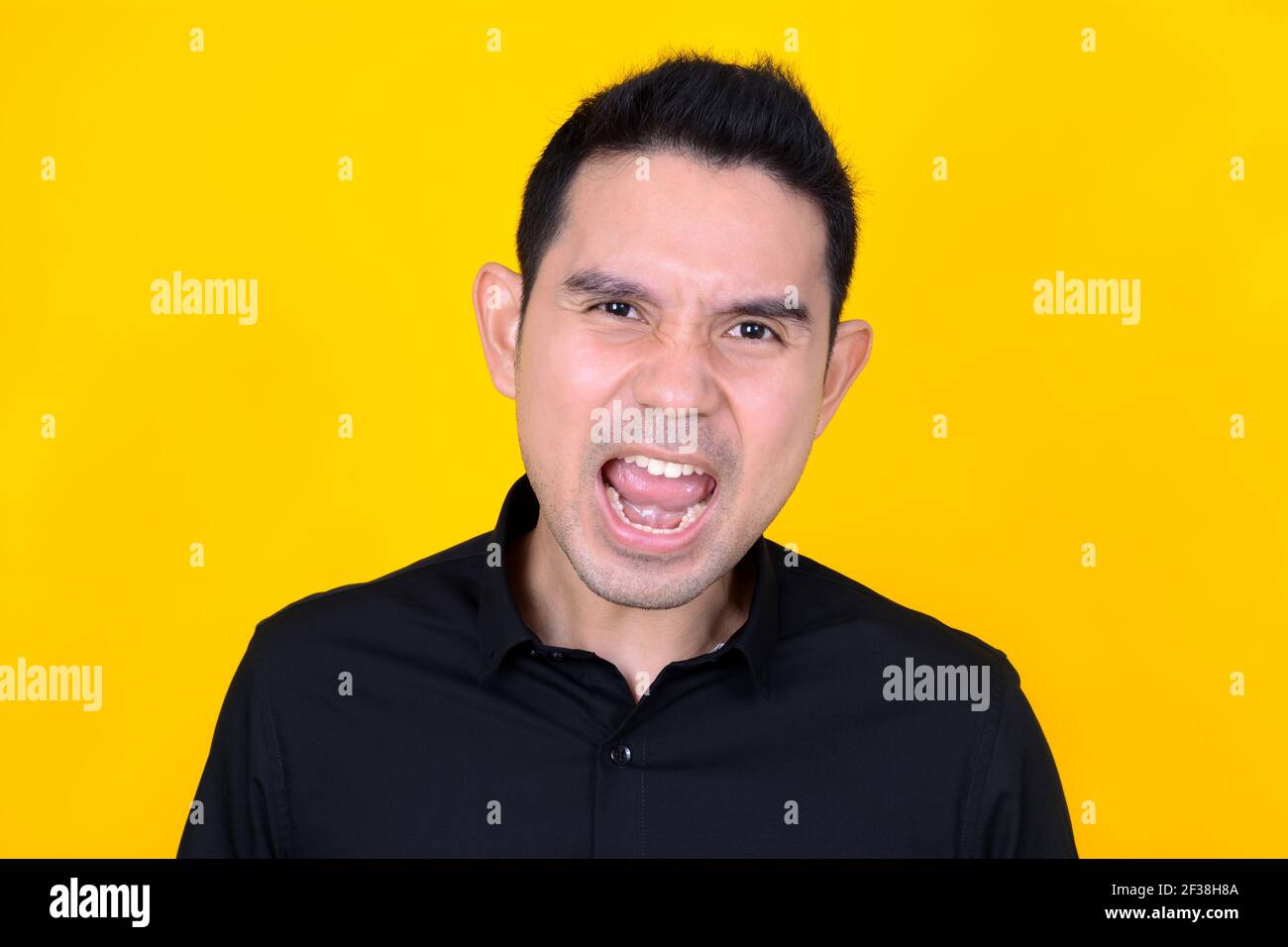 Angry man on yellow background Stock Photo - Alamy