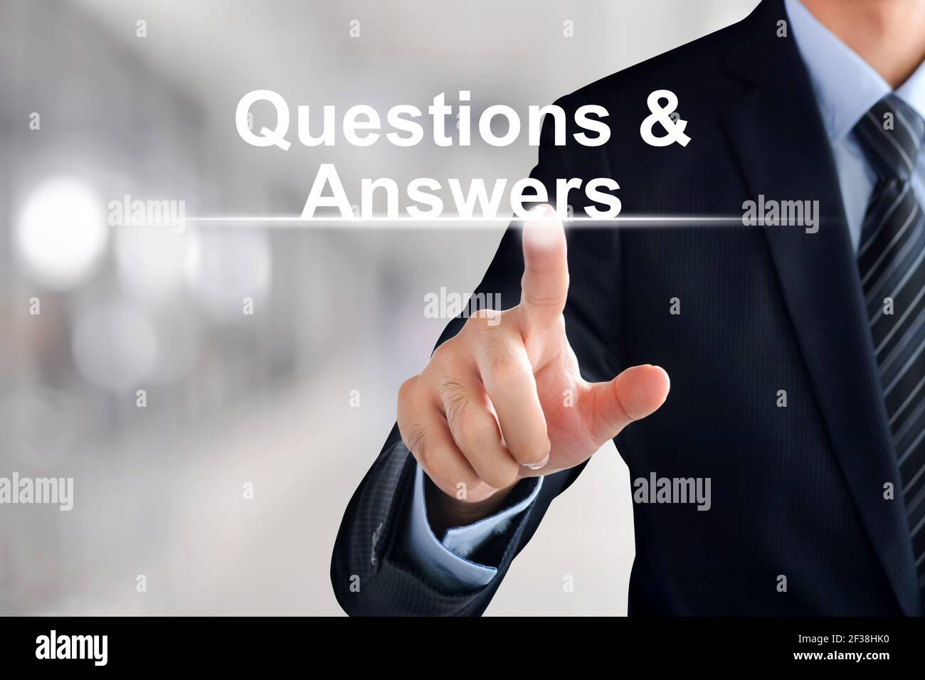 Businessman hand pointing on Question & Answers sign on virtual screen ...
