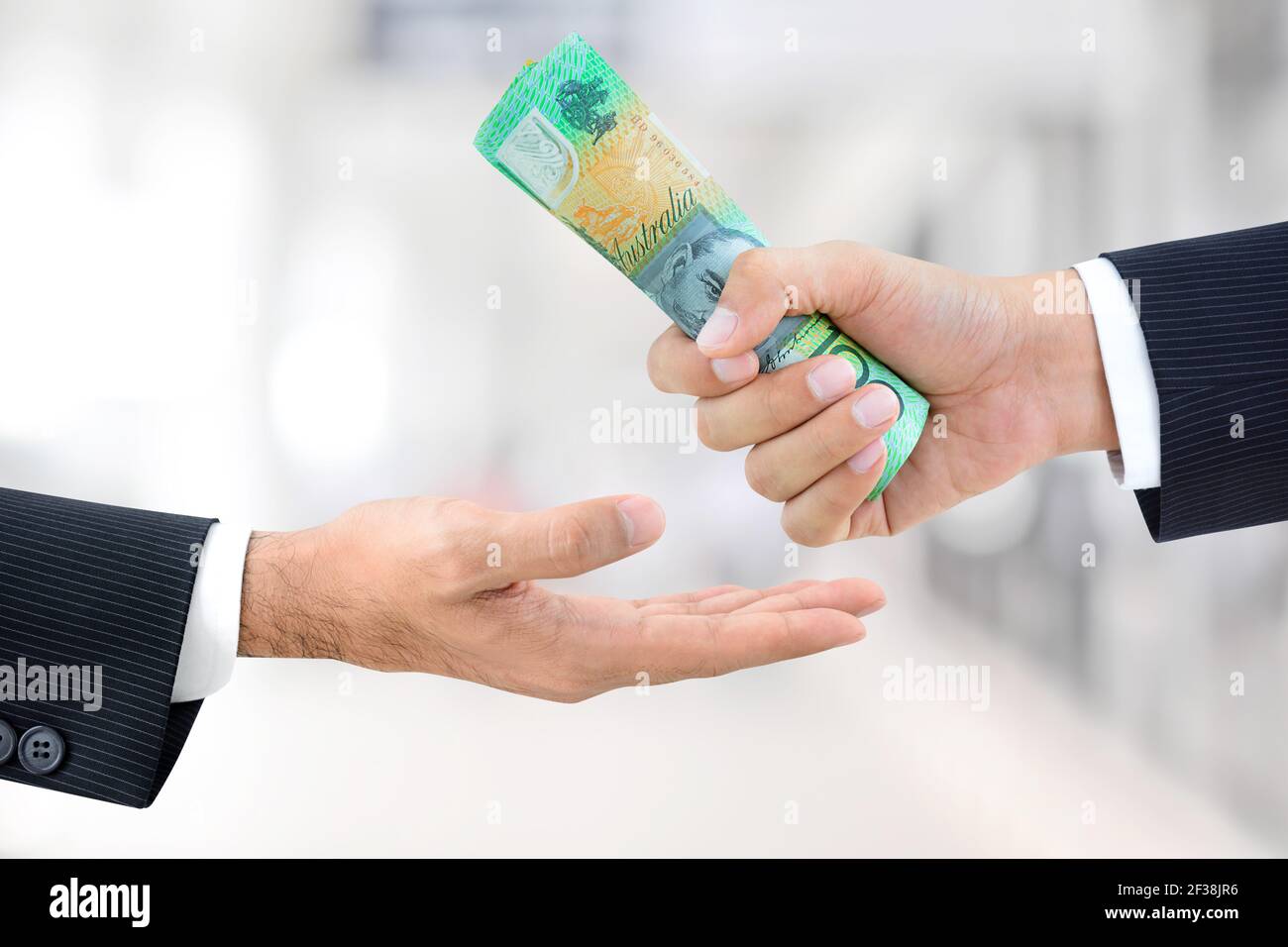 Businessman hands passing money, Australian dollar (AUD) banknotes, on ...