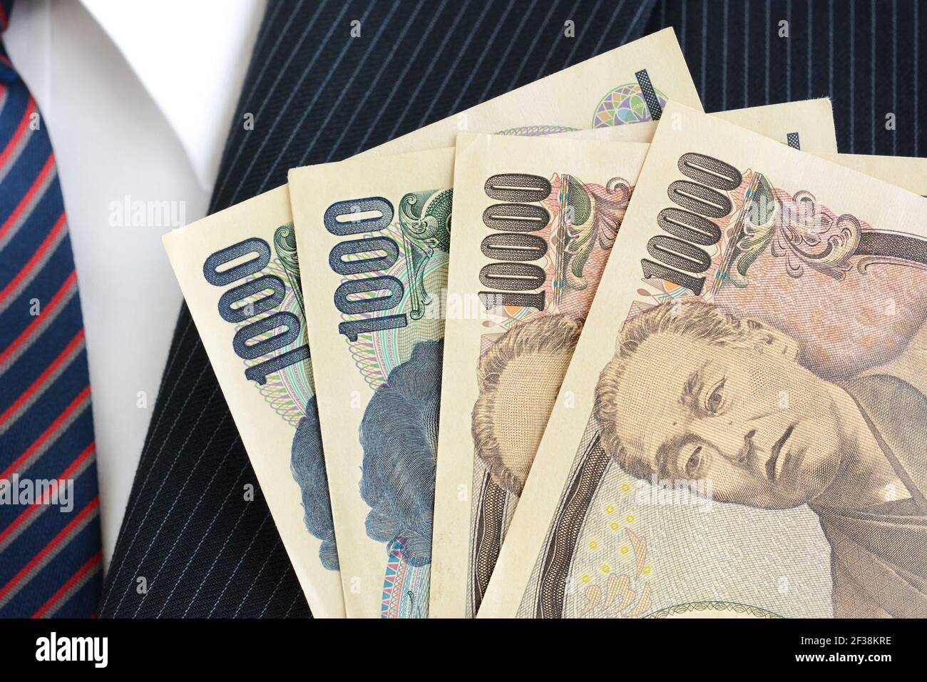 Money, Japanese Yen (JPY) banknotes, on businessman suit background ...