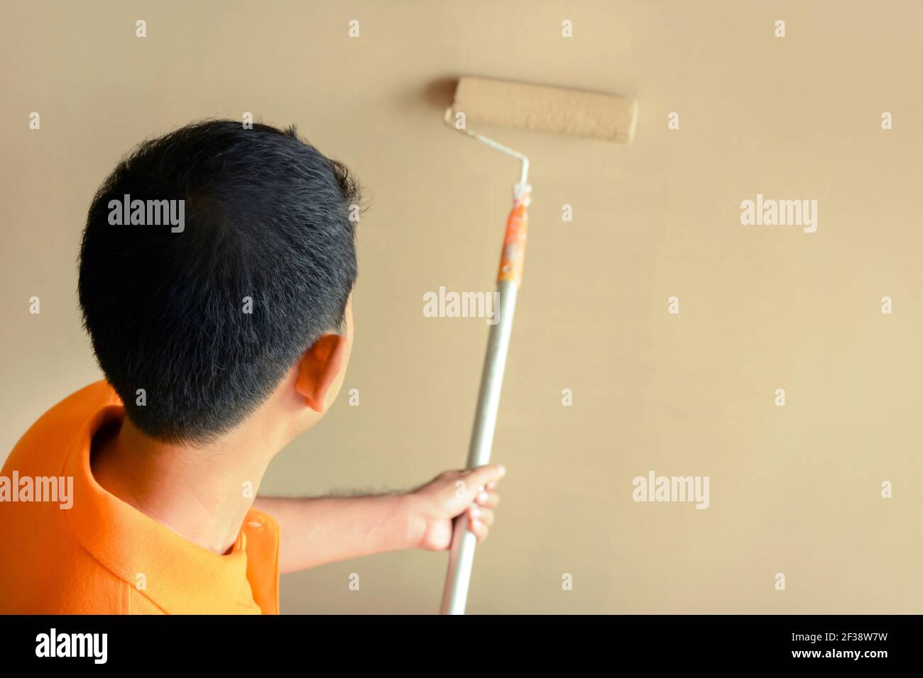 Painter painting wall with roller Stock Photo - Alamy