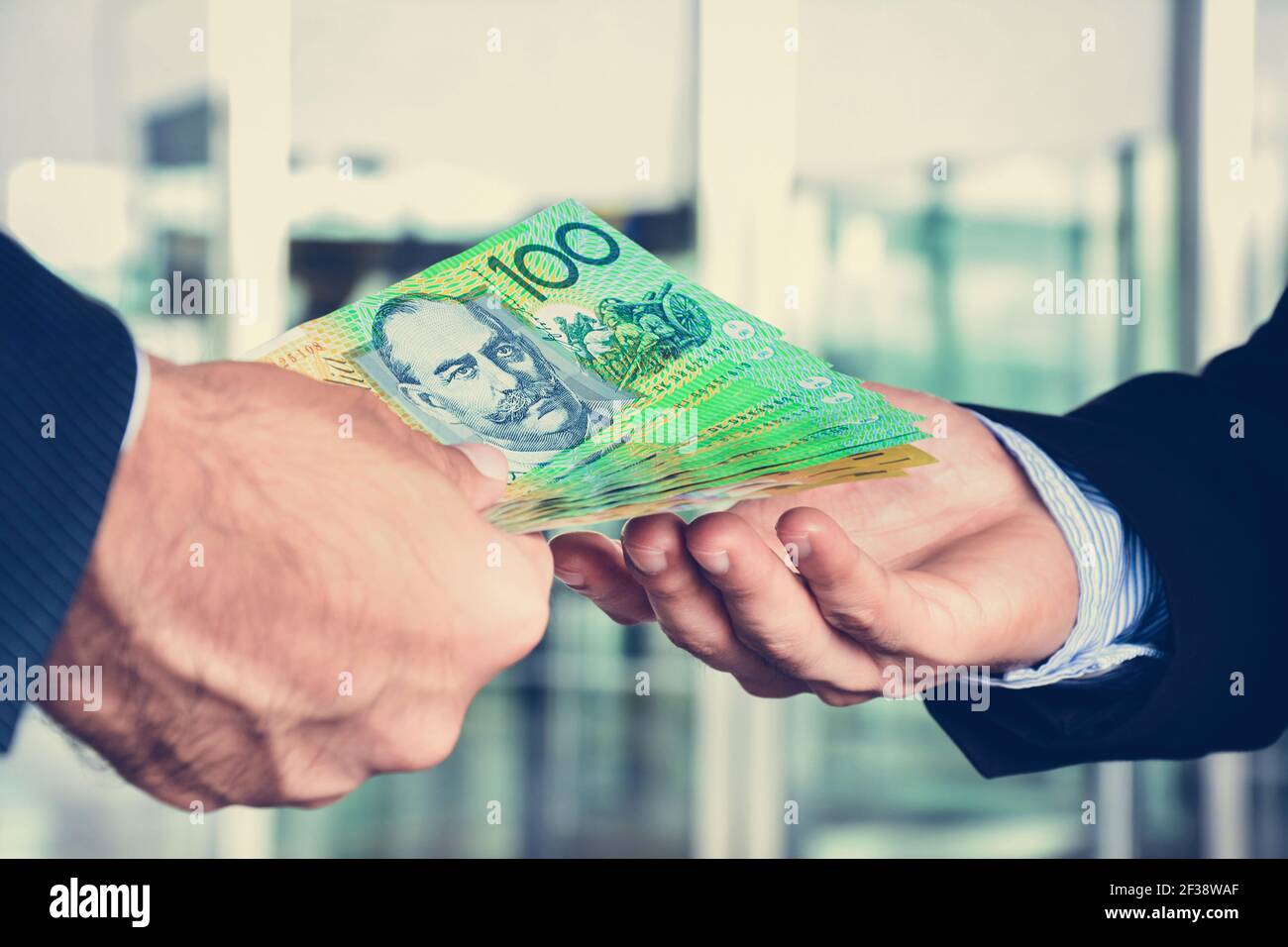 Hands of businessmen passing money, Australia dollar (AUD) banknotes ...