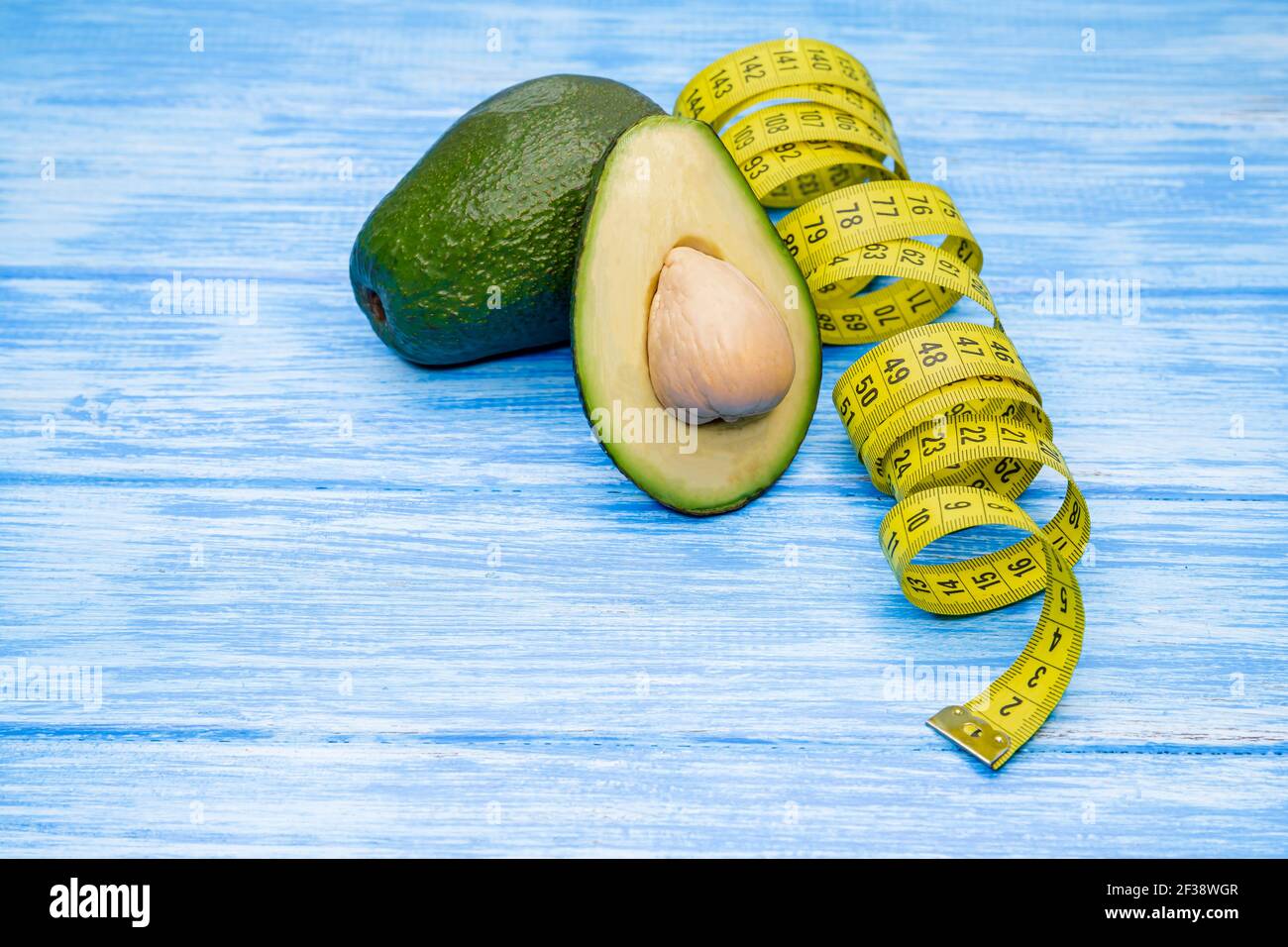 Food background with fresh organic avocado on blue table. Superfood ...