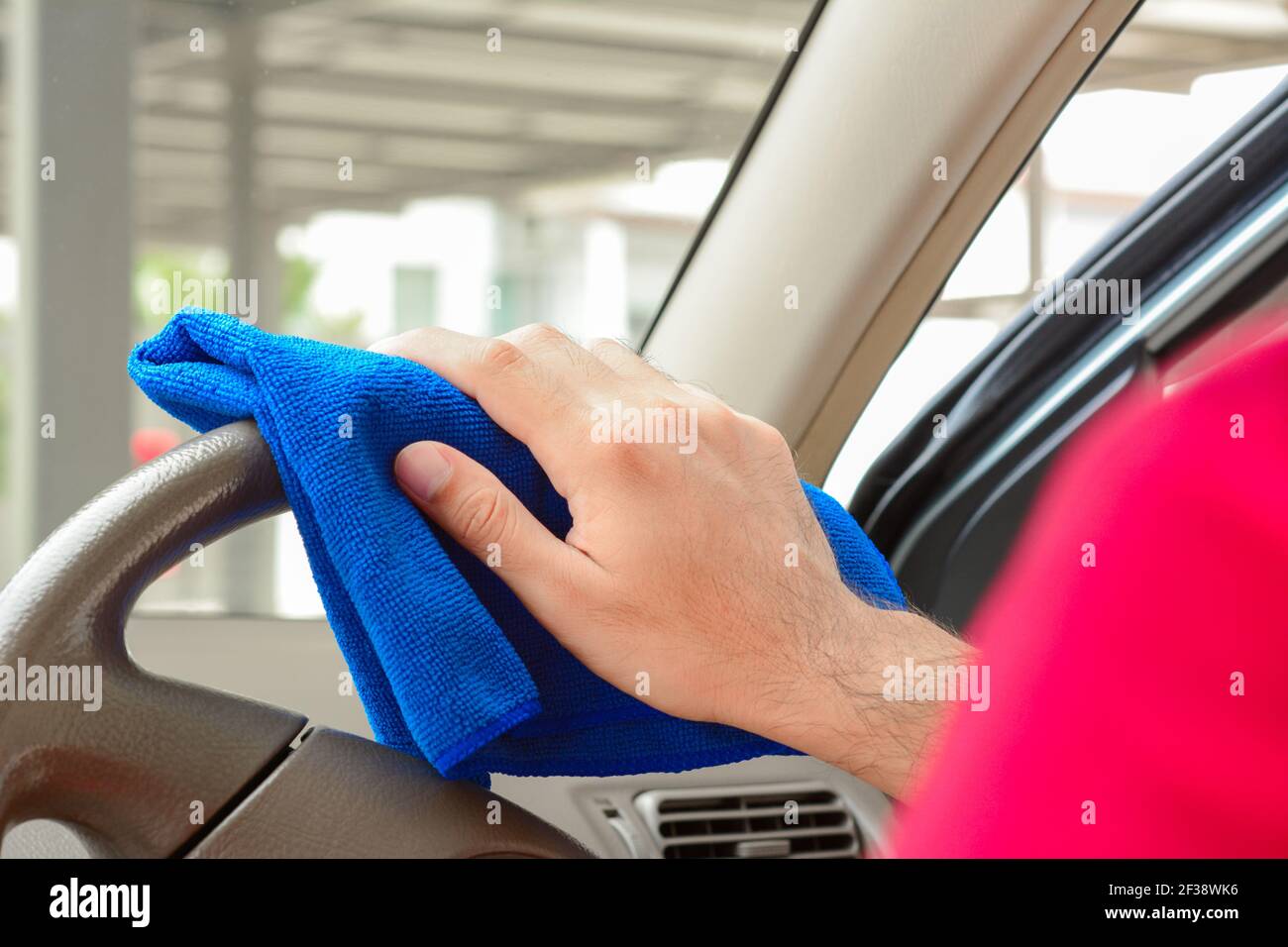 Hand cleaning car steering wheel with microfiber cloth Stock Photo - Alamy