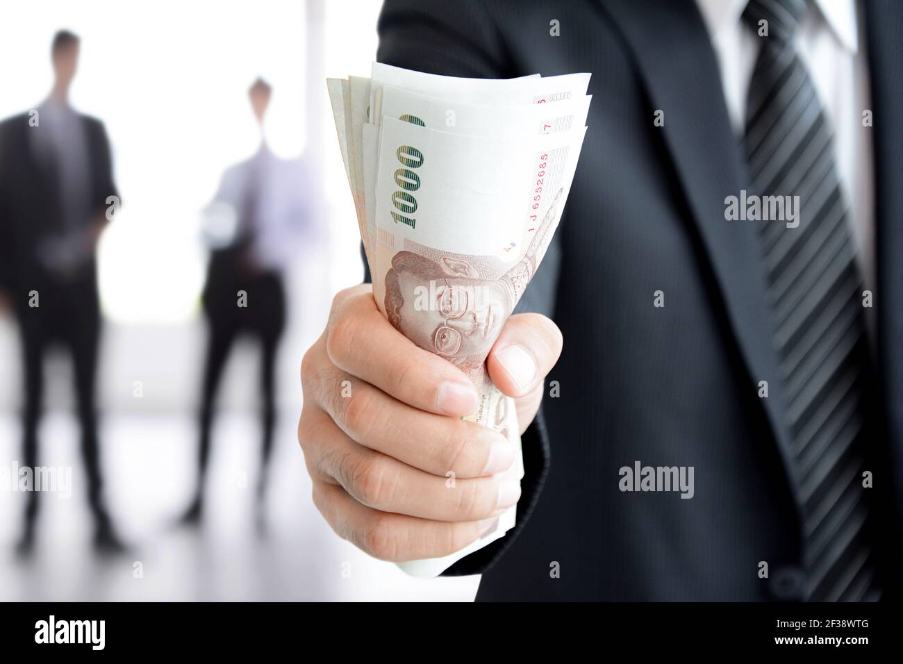 Businessman hand gripping money, Thai Baht (THB) bills - investment ...