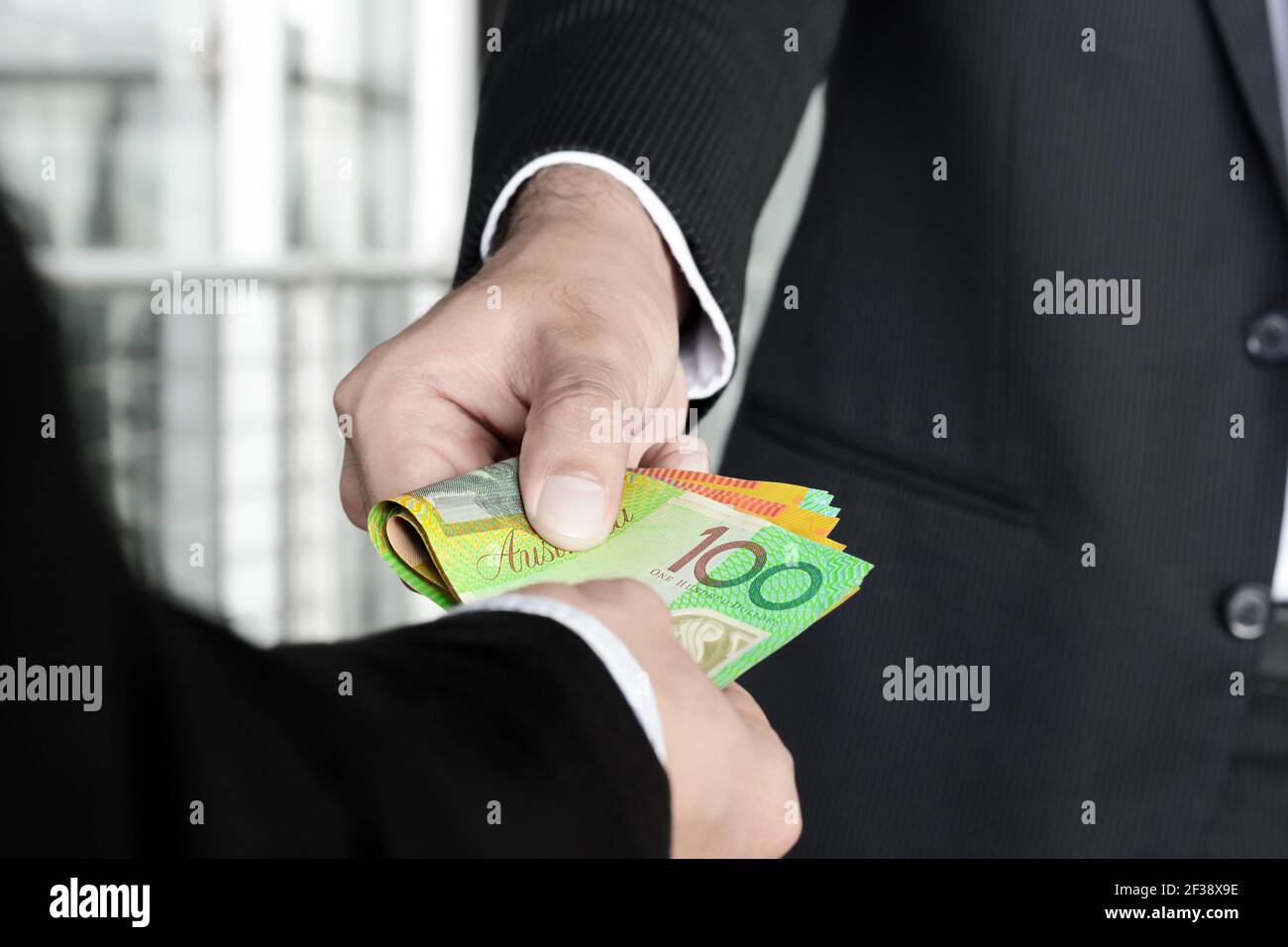 Businessmen passing money, Australia dollar bills Stock Photo - Alamy
