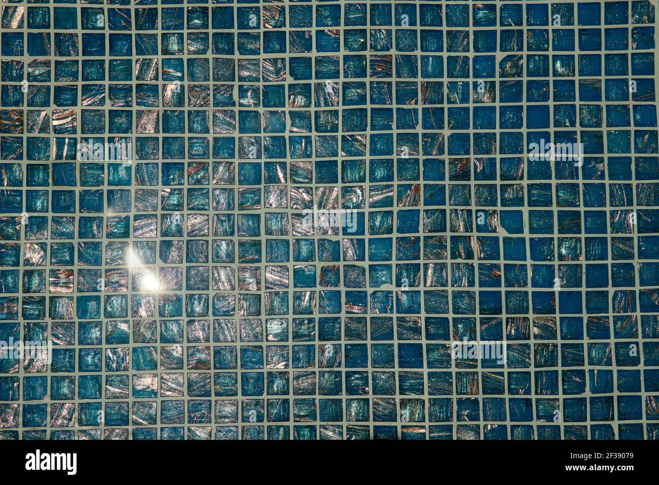 A pool with blue ceramic tiles and water ripple effect. Refection of ...