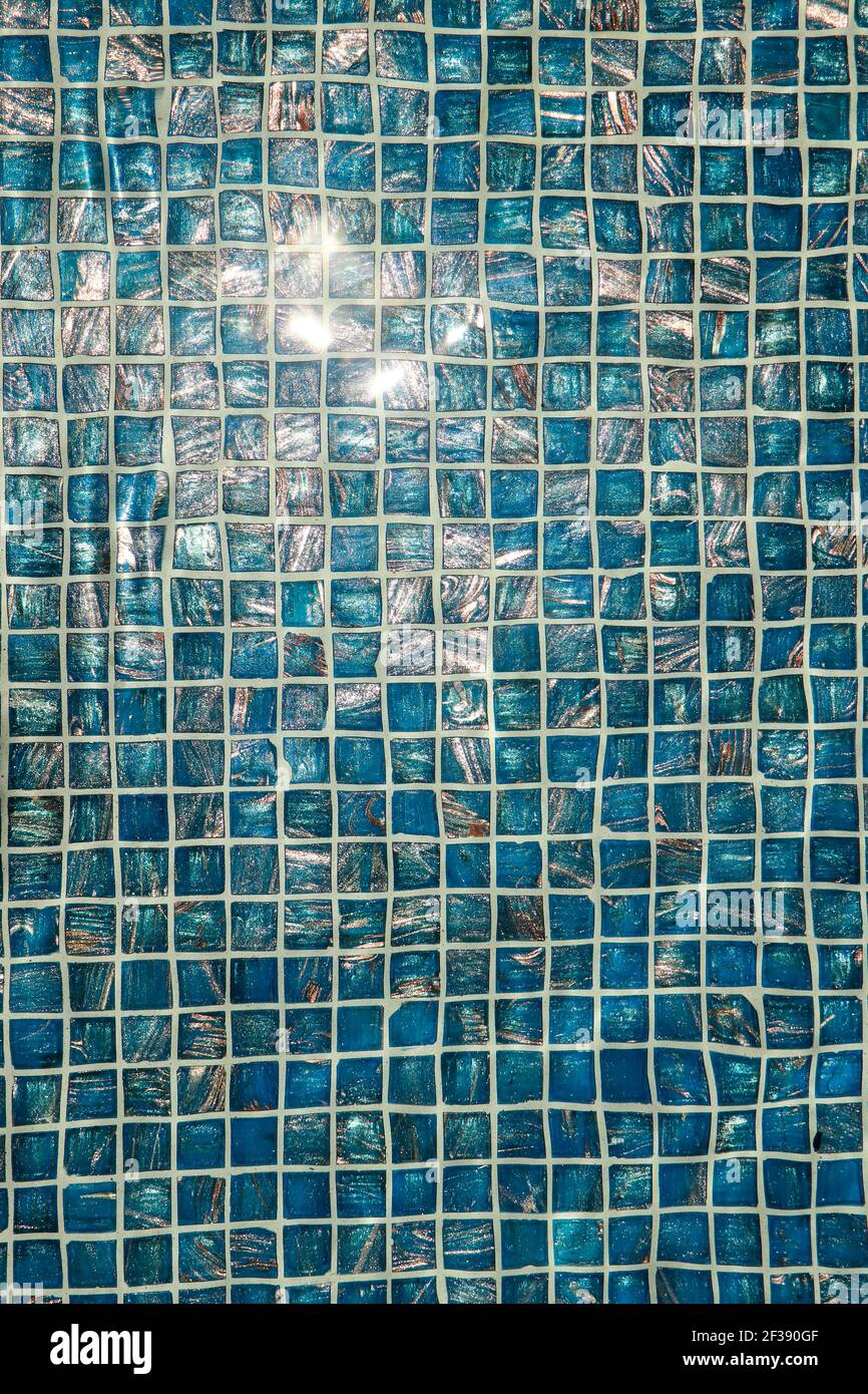 A pool with blue ceramic tiles and water ripple effect. Refection of ...