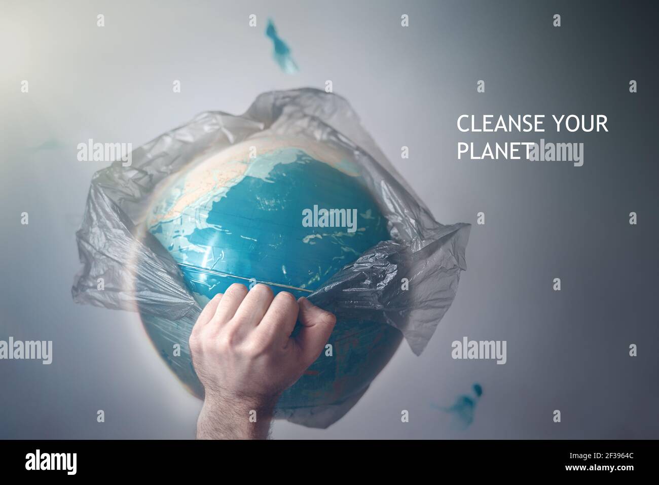 A man breaks a garbage bag which is wrapped globe of planet Earth. The ...