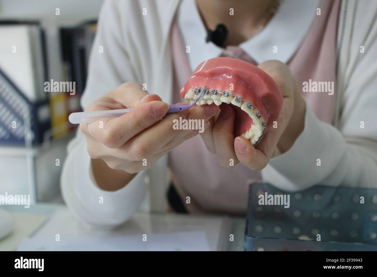 Dental staff showing how to clean between braces Stock Photo - Alamy