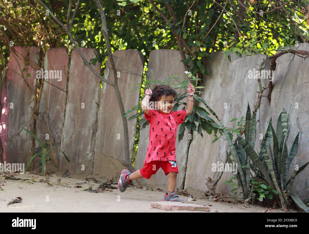 A small Hindu child resident in India playing a game of running in the ...