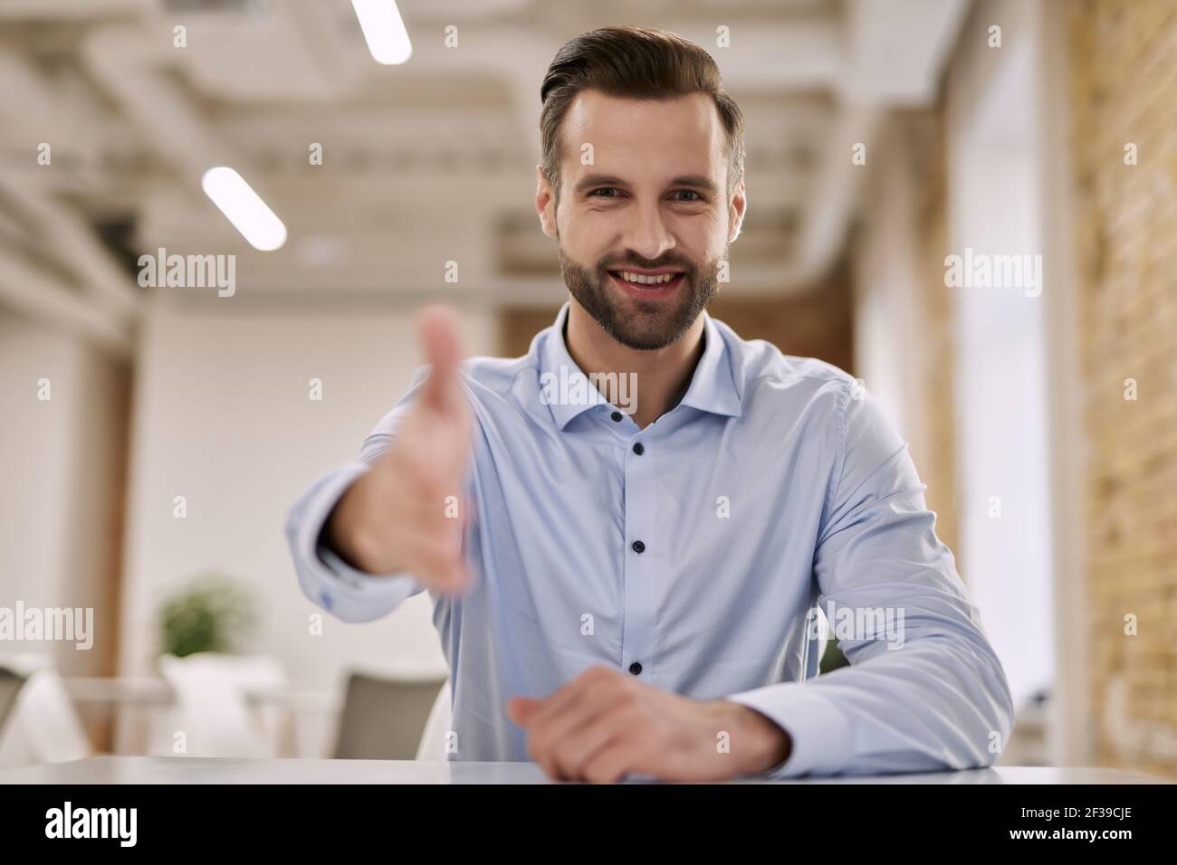 Friendly manager giving his hand in welcoming gesture Stock Photo - Alamy