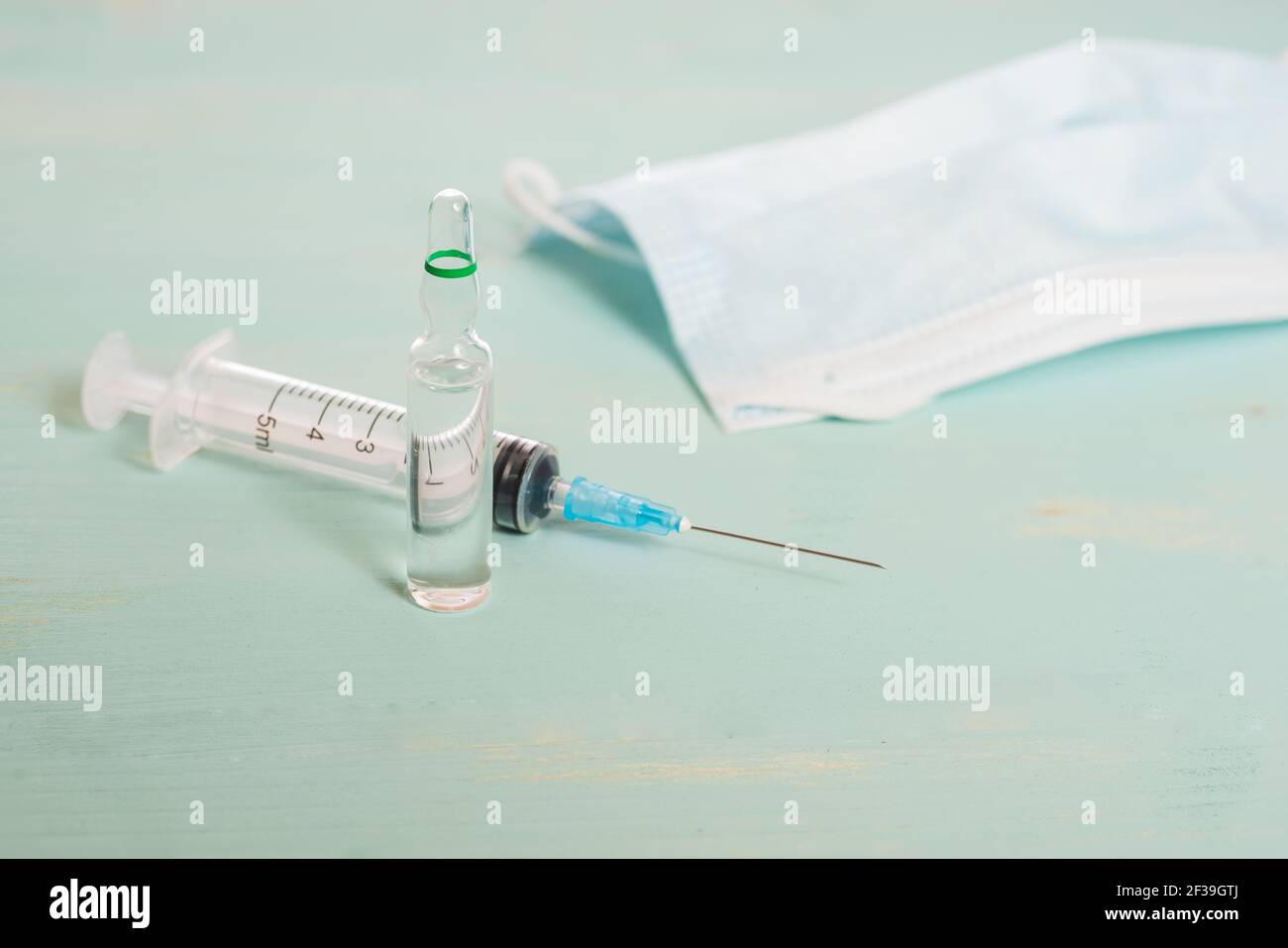 Medical vials,medical mask and syringe isolated on green background ...