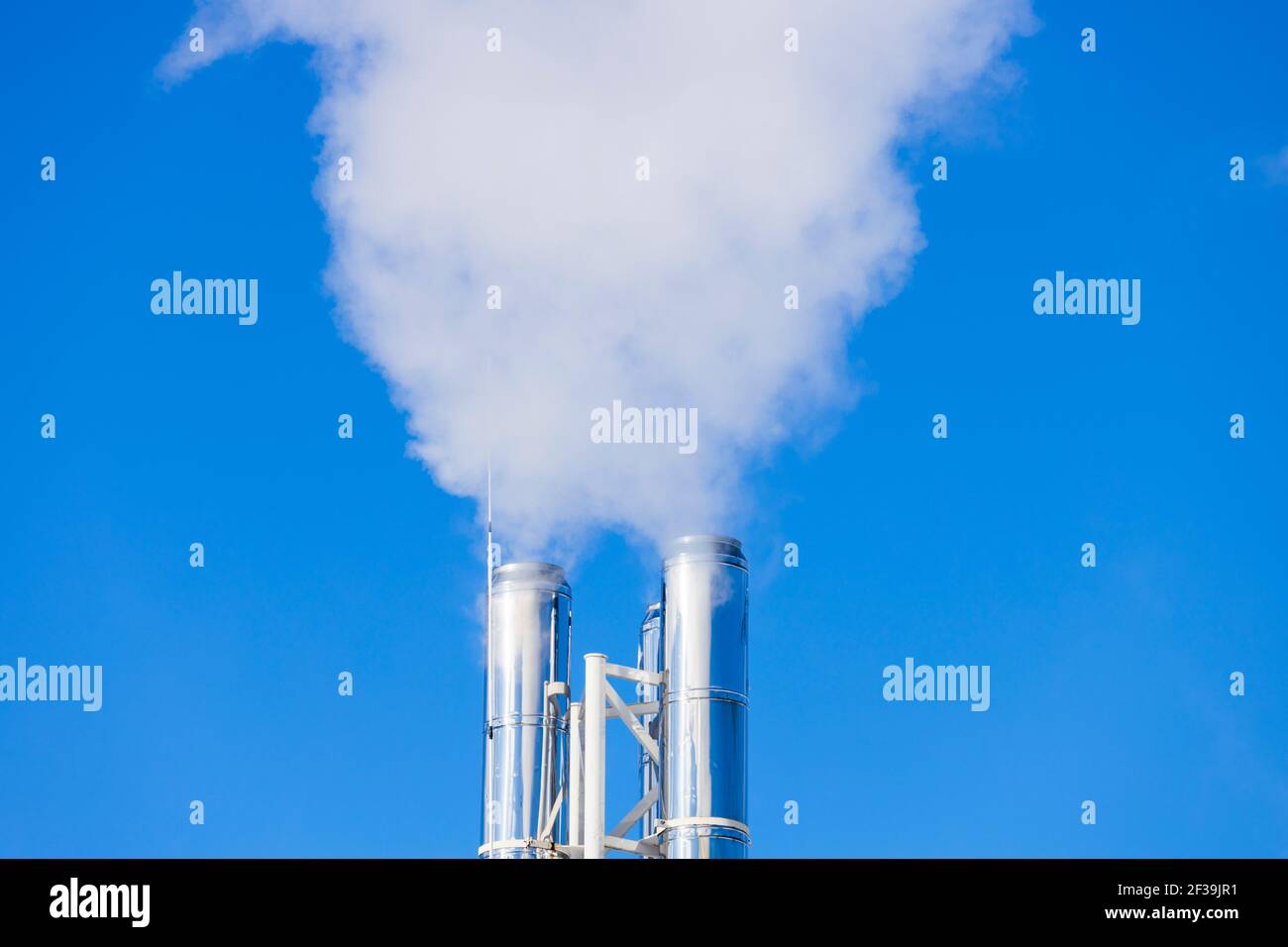 silver pipes from which smoke billows. working boiler room. High ...