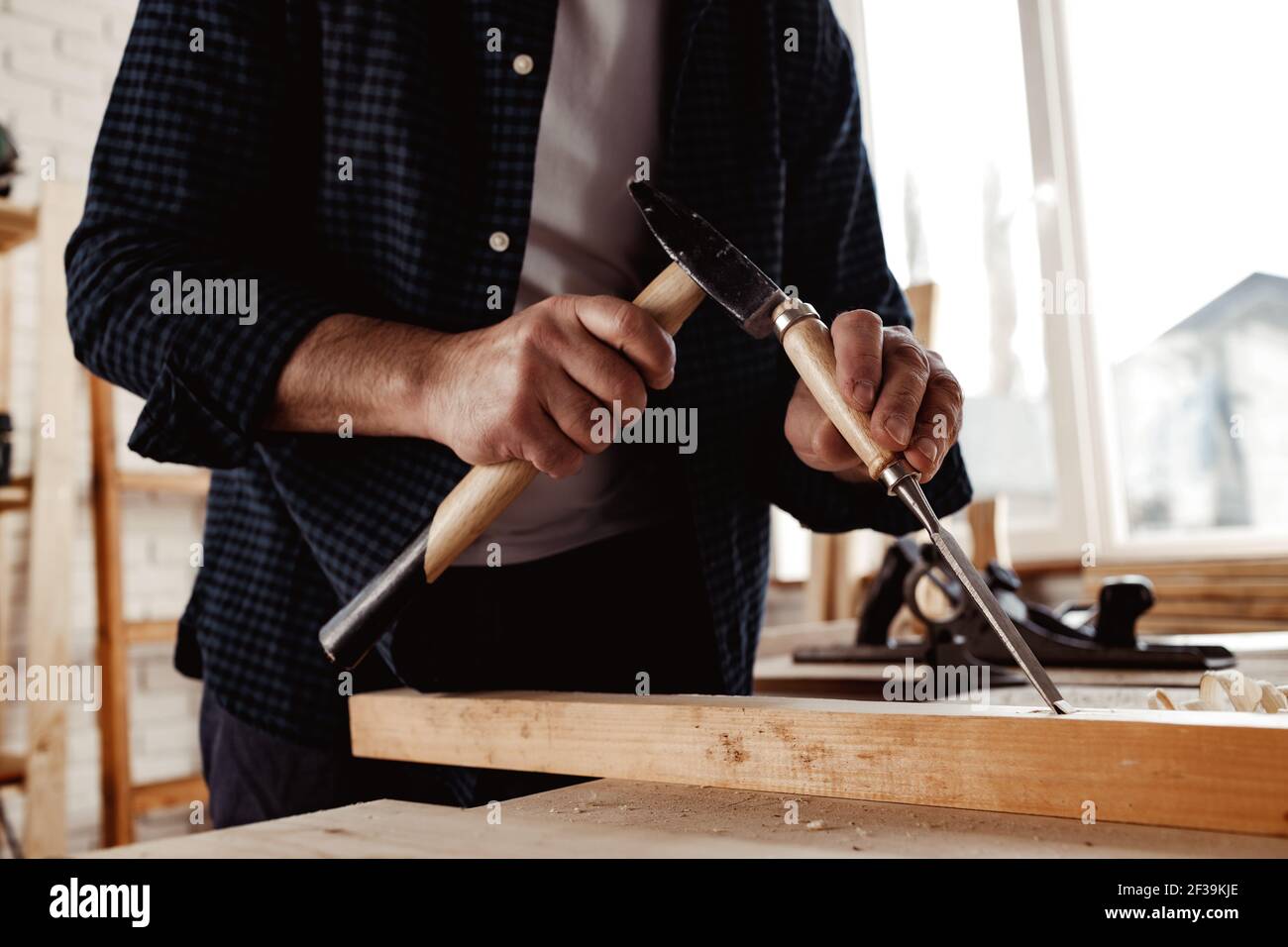 Hands of a carpenter working with chisel and hammer Stock Photo - Alamy