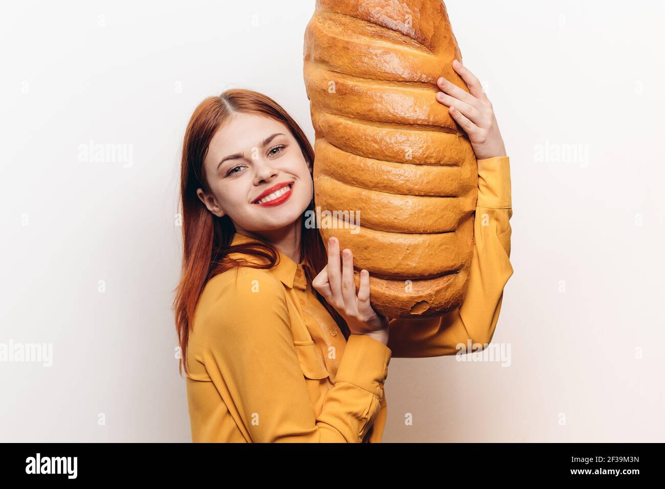 woman with a loaf in her hands on a light background emotions model fun ...