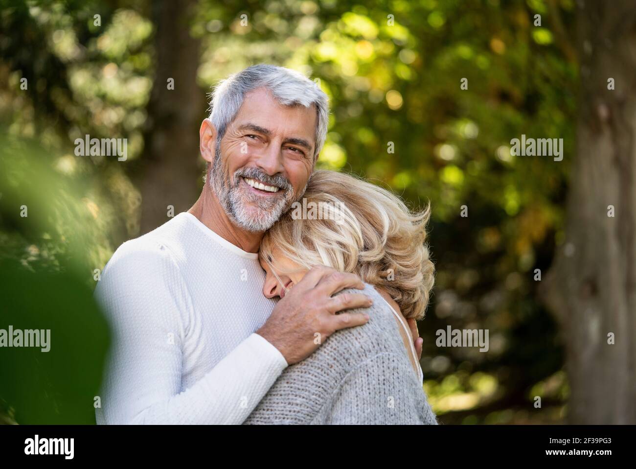 Smiling mature couple embracing each other in backyard Stock Photo - Alamy