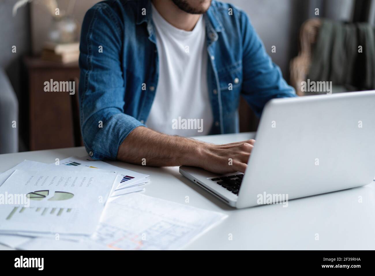 Entrepreneur working with a laptop and holding a document in a little ...