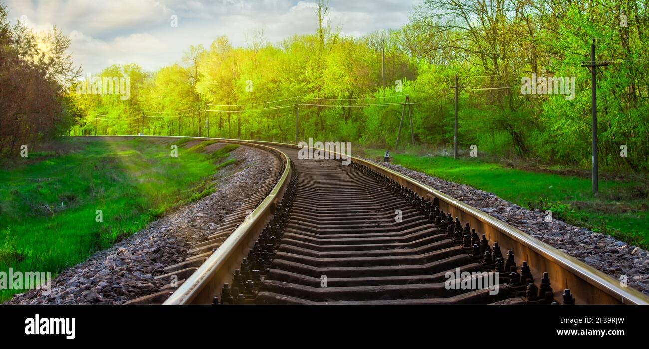 Morning landscape on the railway tracks. The sun rays are the green ...