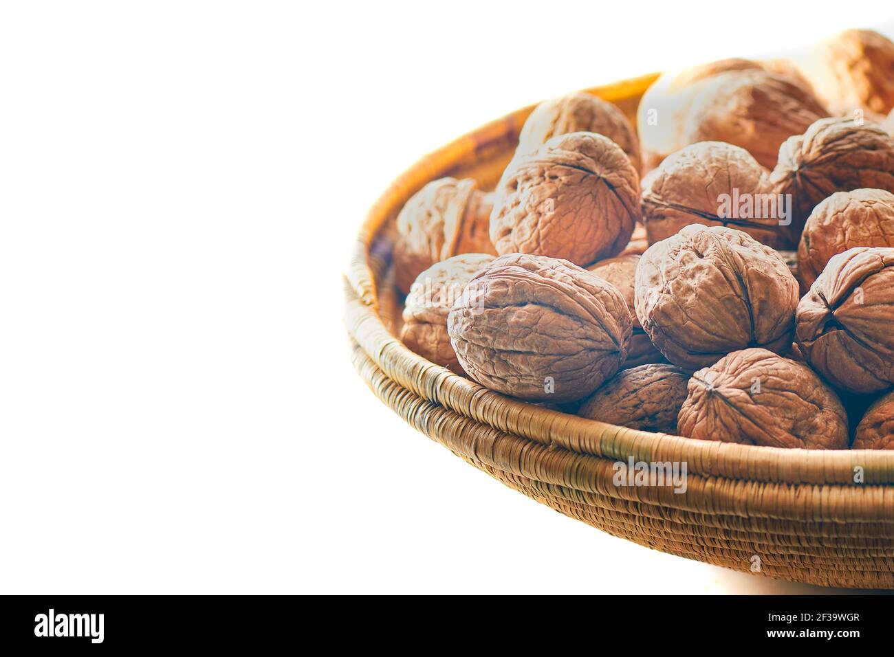 Walnut basket near the window creating white background Stock Photo - Alamy
