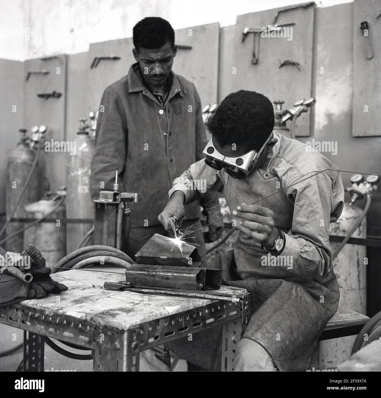 1960s, historical, a tutor overseeing a male engineering apprentice ...