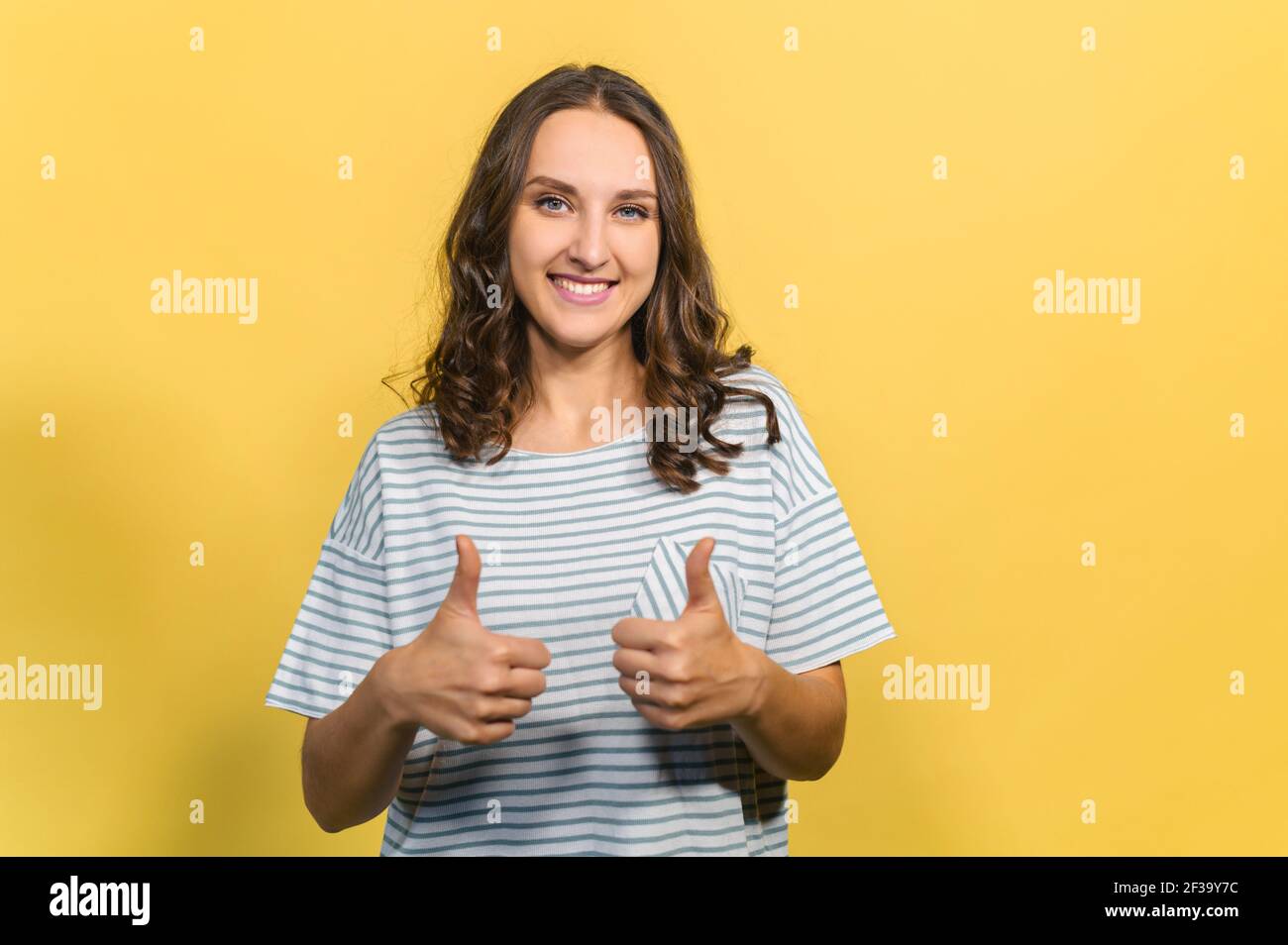 Beautiful Brunette Woman Wearing Striped T Shirt Showing Thumbs Up At