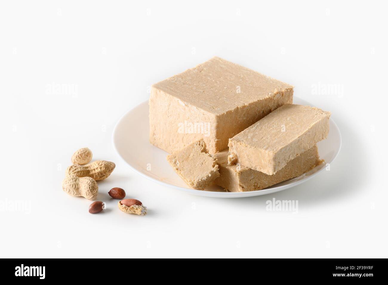 Eastern sweet dessert peanut halva in plate isolated on white ...