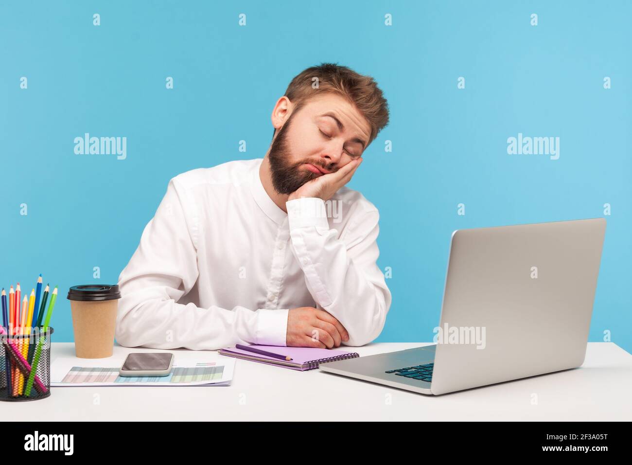 Bored sleepy man office worker napping sitting at workplace with laptop ...