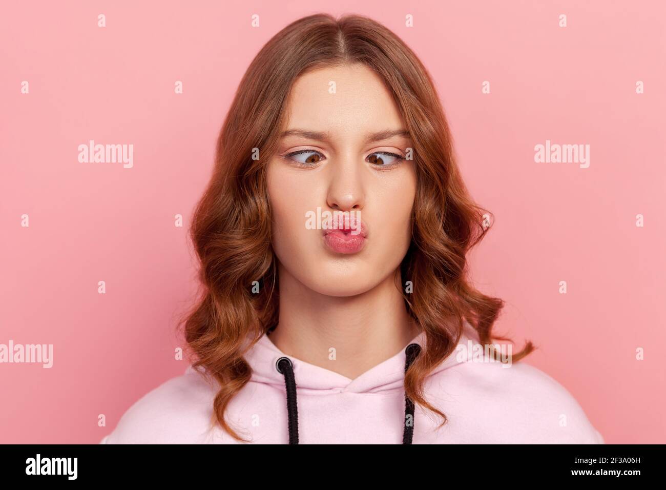 Closeup portrait of funny teenager girl with curly hair making silly ...