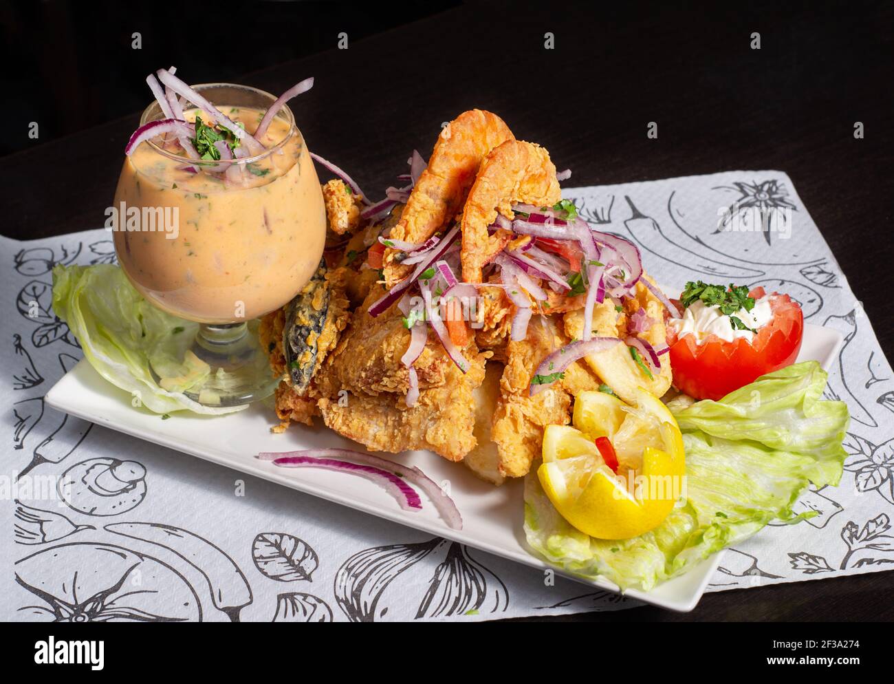 Peruvian traditional food. Fried fish with shrimp, onion, lemon ...