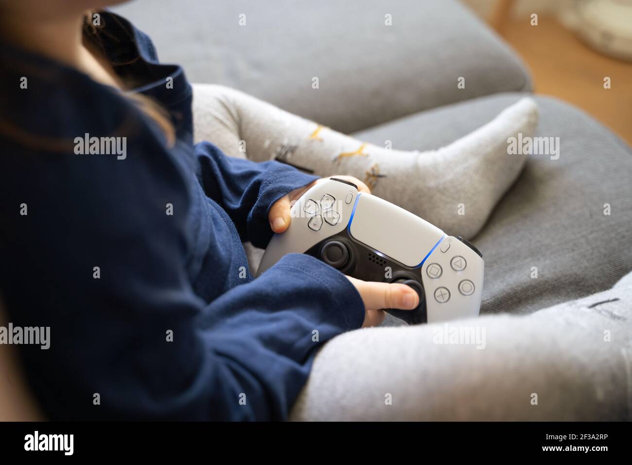 Small child playing video games with gamepad on console. Modern kids ...