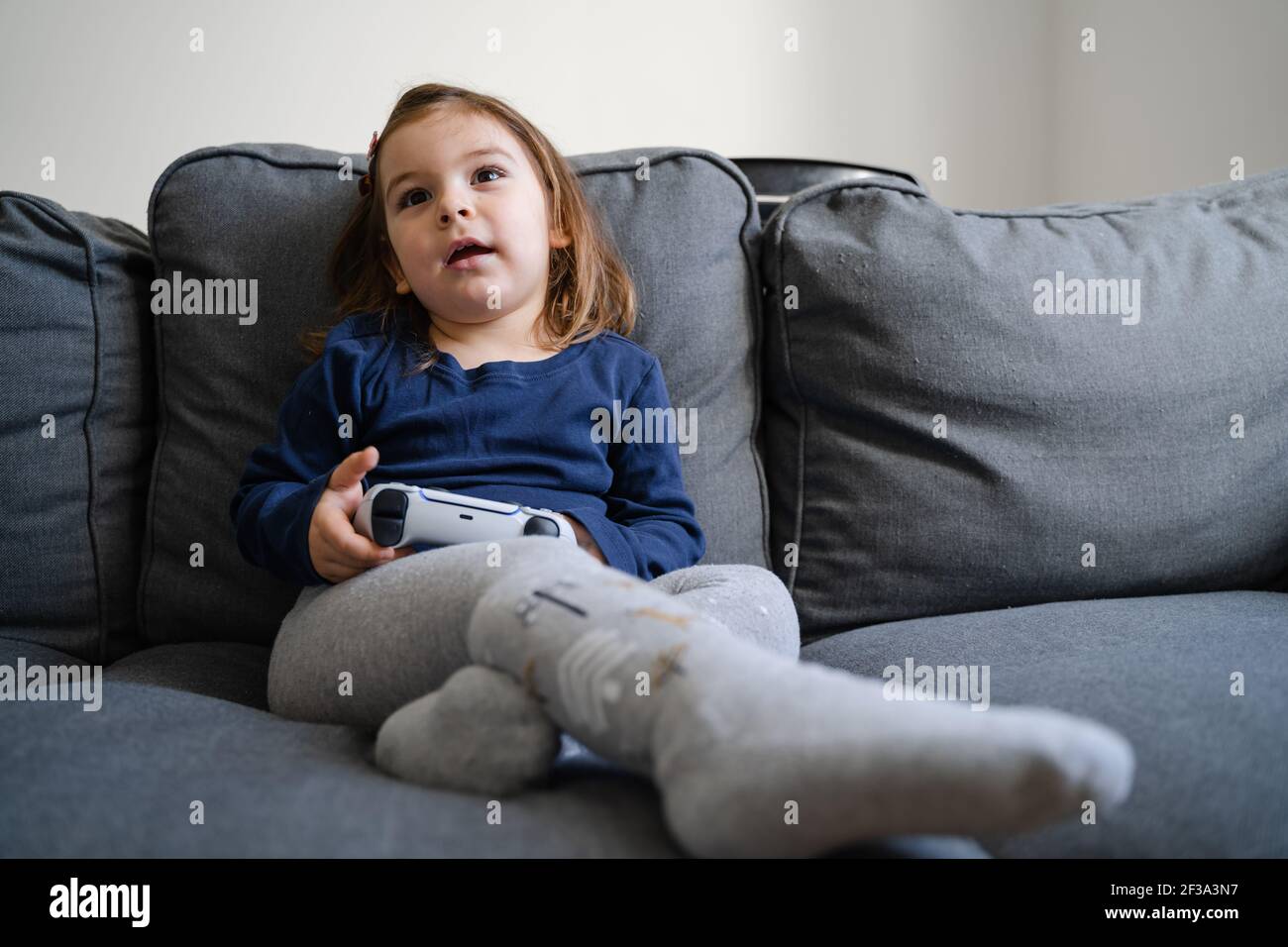 Small child playing video games with gamepad on console. Modern kids ...