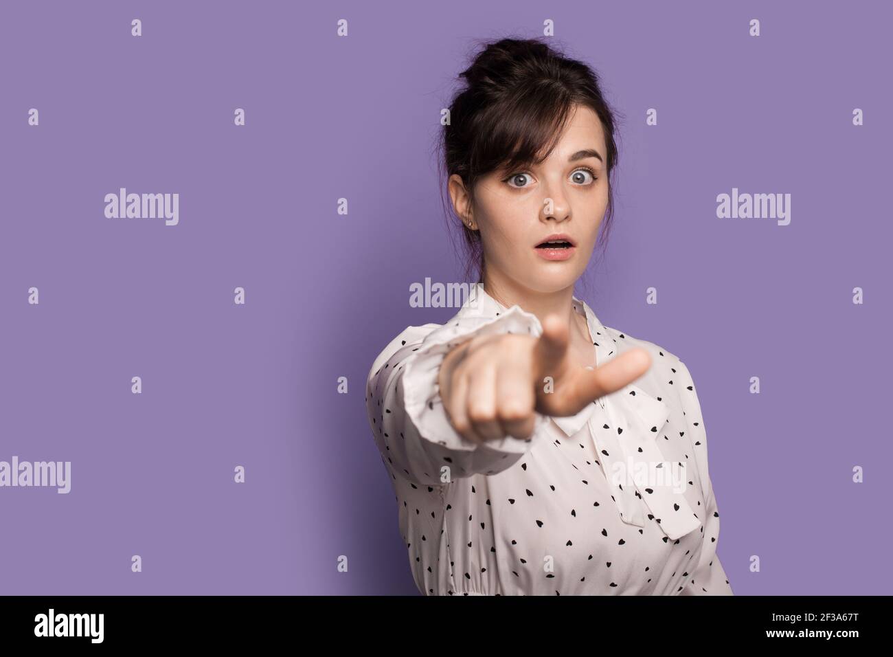 Caucasian woman is pointing at the screen with forefinger looking ...