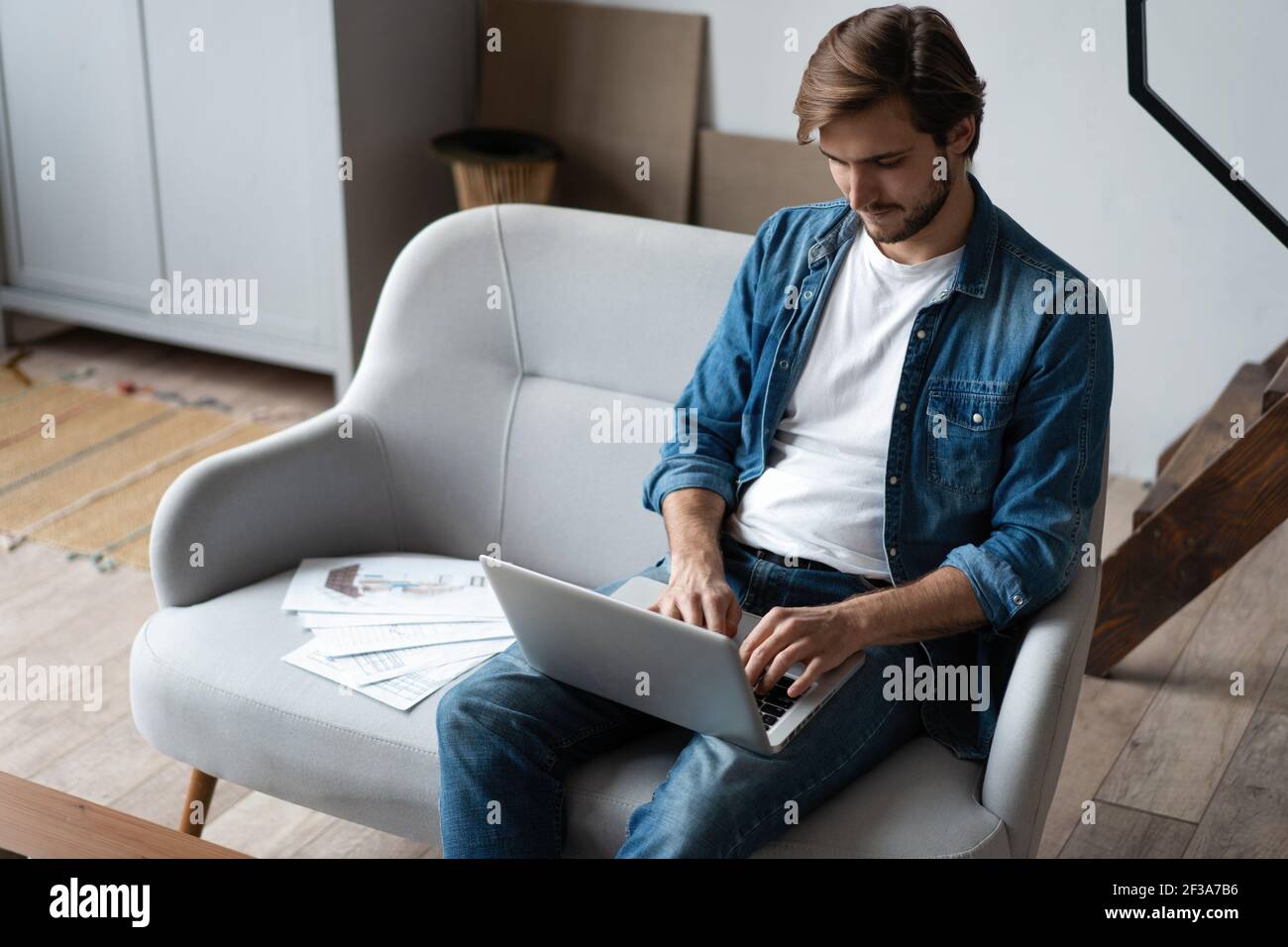 Entrepreneur working with a laptop and holding a document in a little ...
