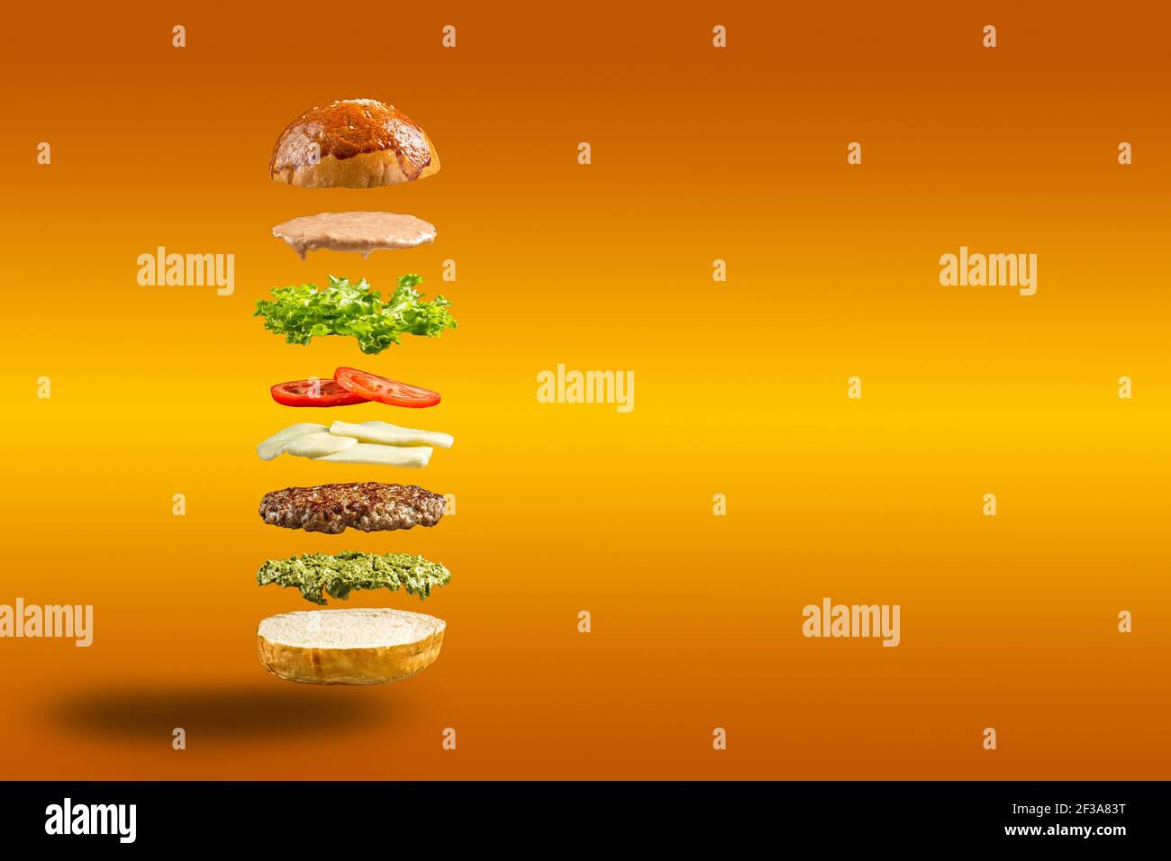 Floating burger ingredients on the yellow background Stock Photo - Alamy