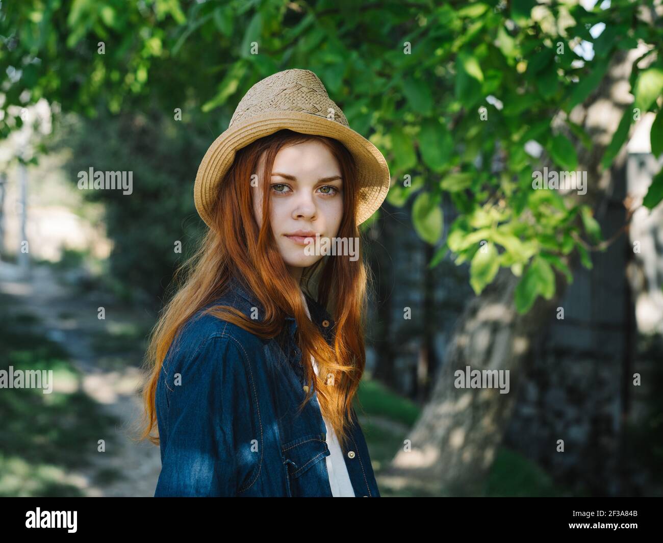 Happy traveler in hat and denim jacket outdoors in countryside Stock ...