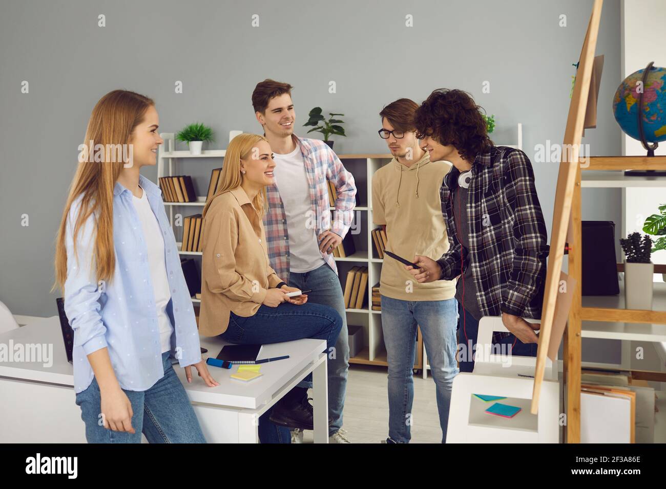 Smiling motivated high school students hold a meeting discussing new ...