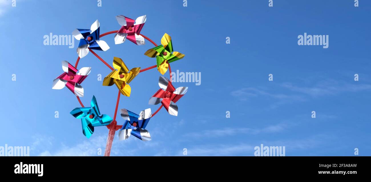 Pinwheel swirling wind on blue sky background. Windmill concept for ...