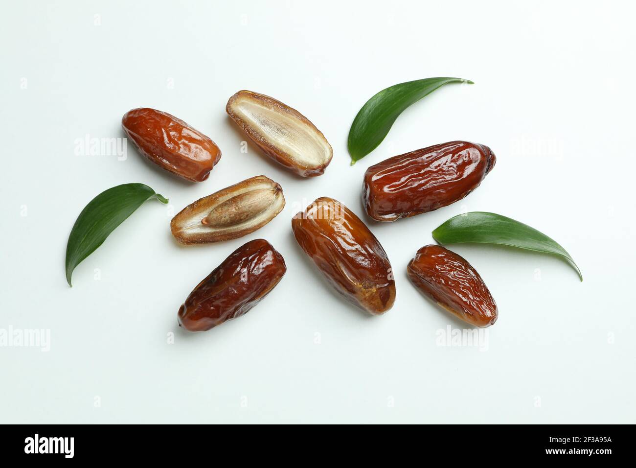 Tasty dried dates with leaves on white background Stock Photo - Alamy