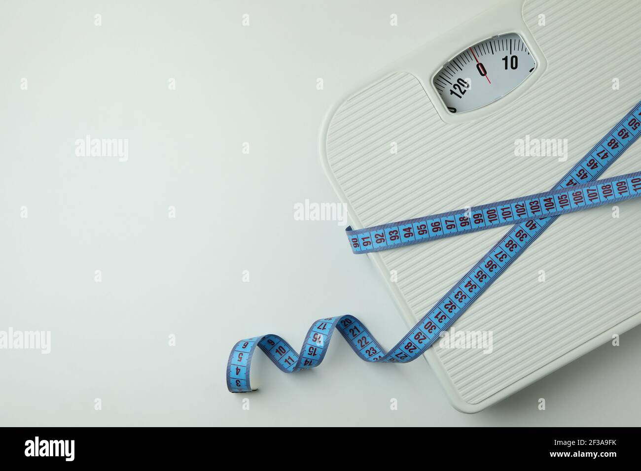 Scales with measuring tape on white background Stock Photo - Alamy