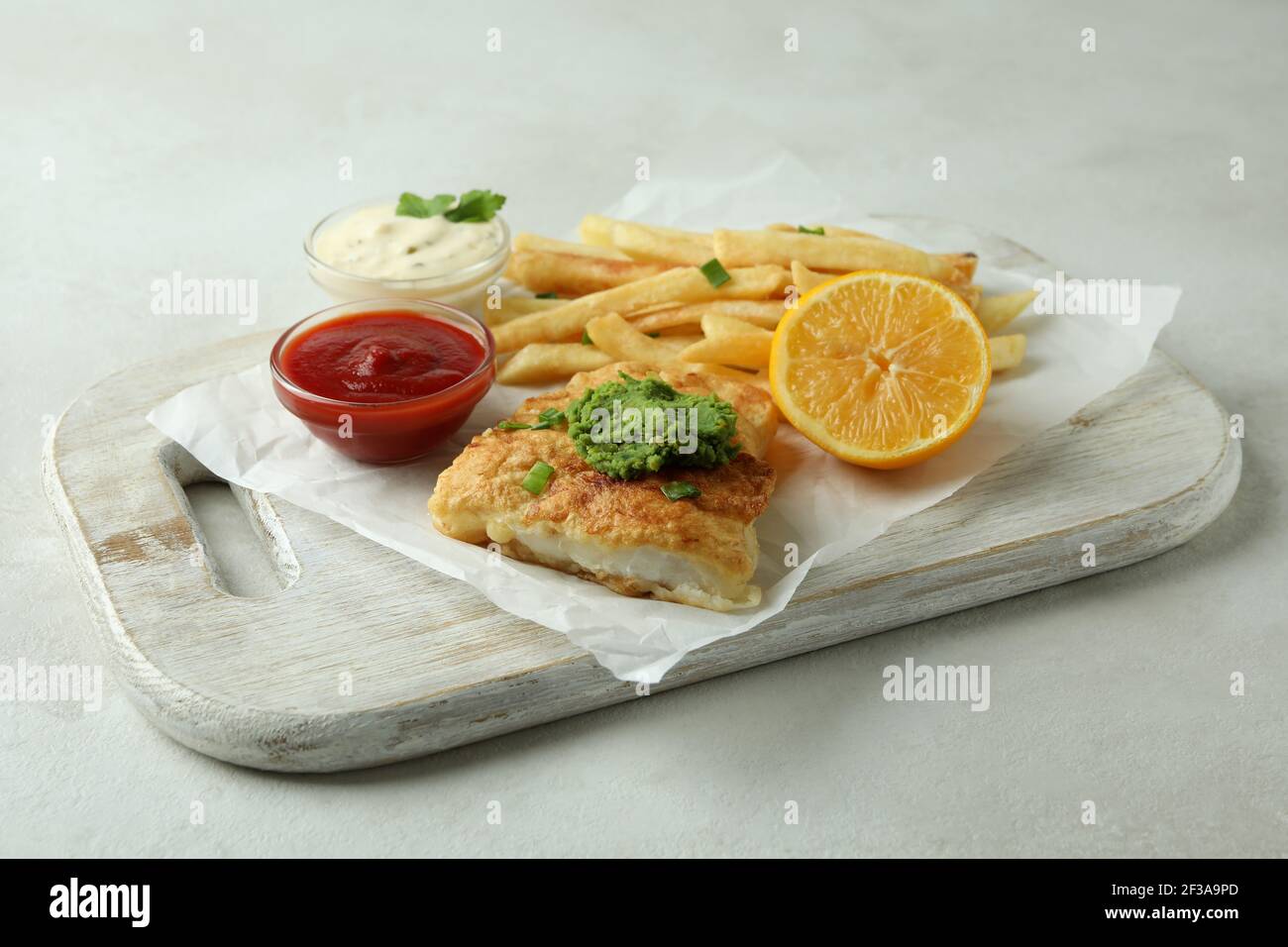 Concept of tasty eating with fried fish and chips on white textured ...