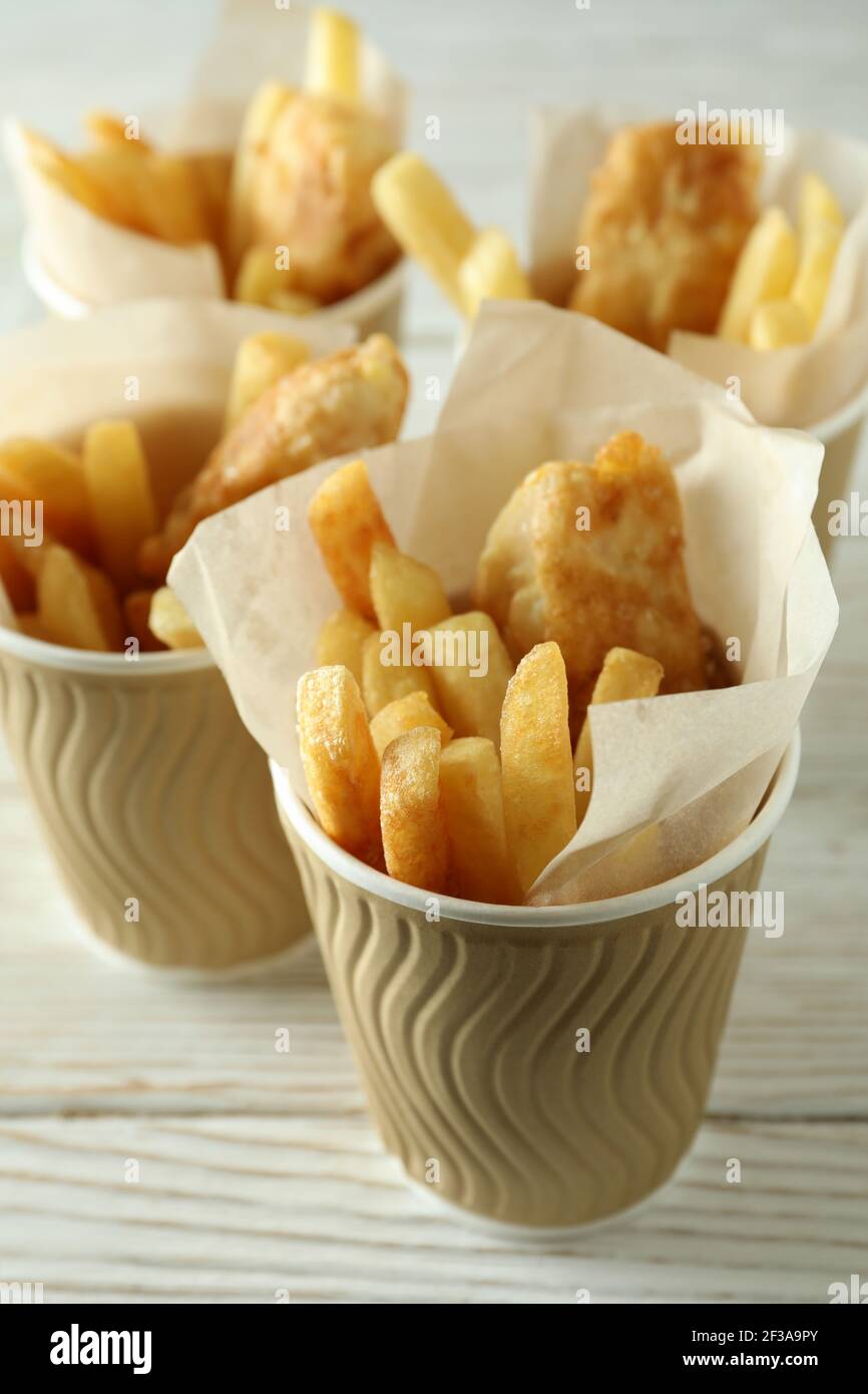 Paper cups with fried fish and chips on wooden background Stock Photo ...