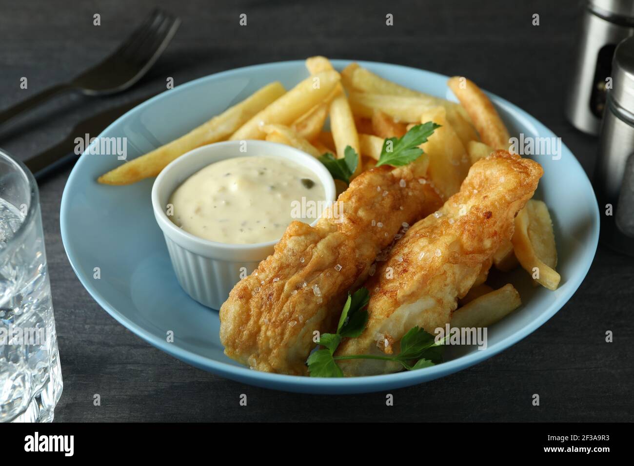 Concept of tasty eating with fried fish and chips on dark textured ...