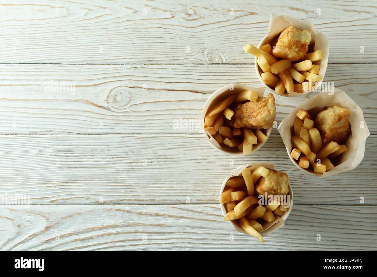 Paper cups with fried fish and chips on wooden background Stock Photo ...