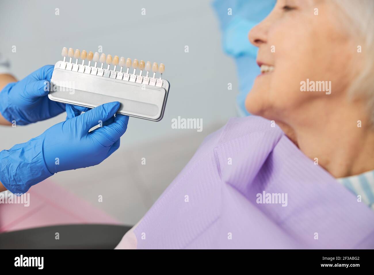 Dental doctor introducing teeth shade guide to aging female Stock Photo ...