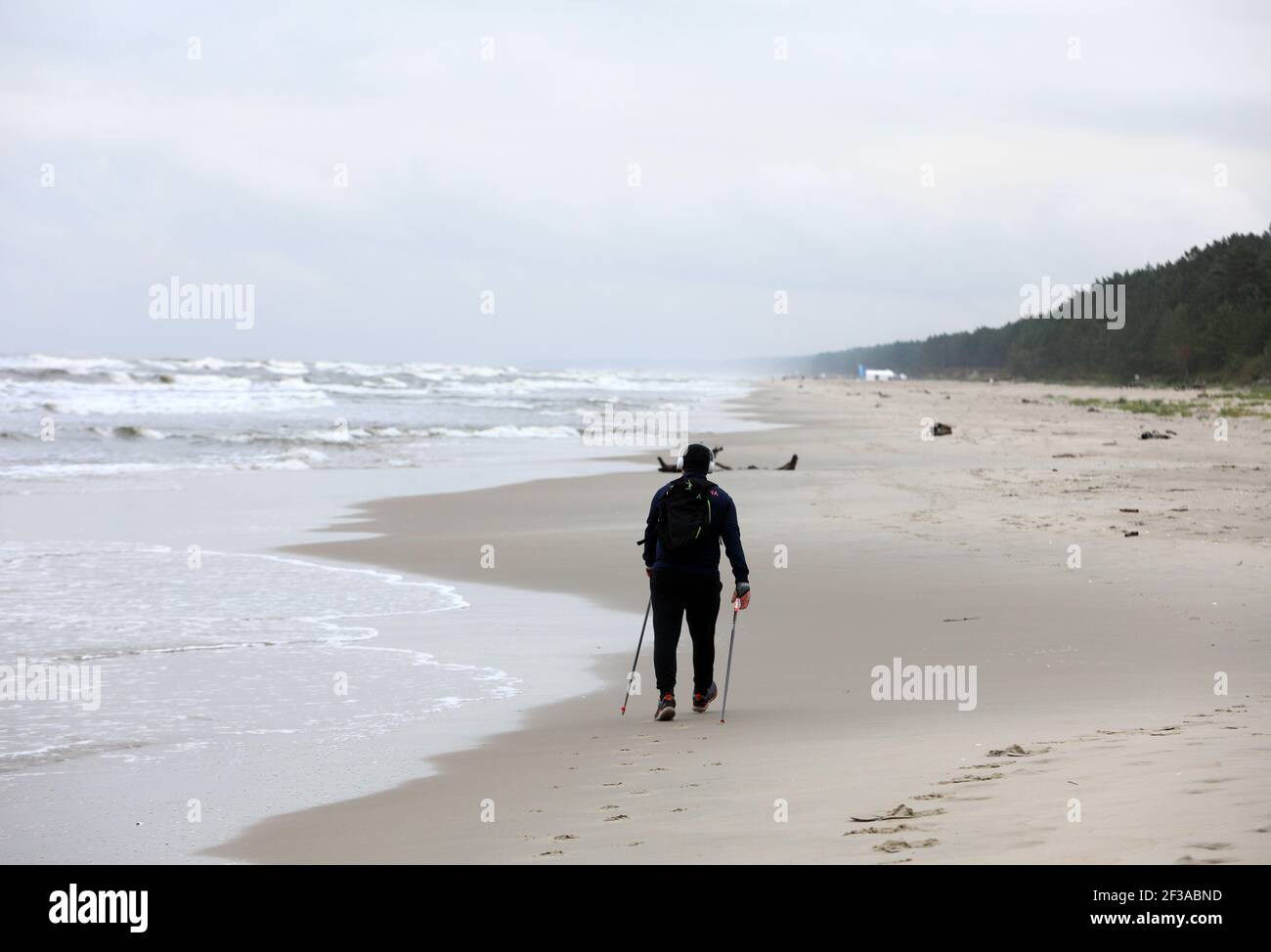 Active and healthy lifestyle. Nordic walking on a sandy beach sea shore ...