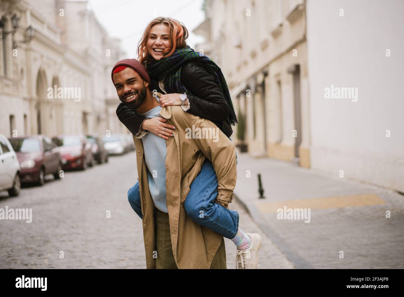 Happy afro american man giving piggyback ride his laughing girlfriend ...