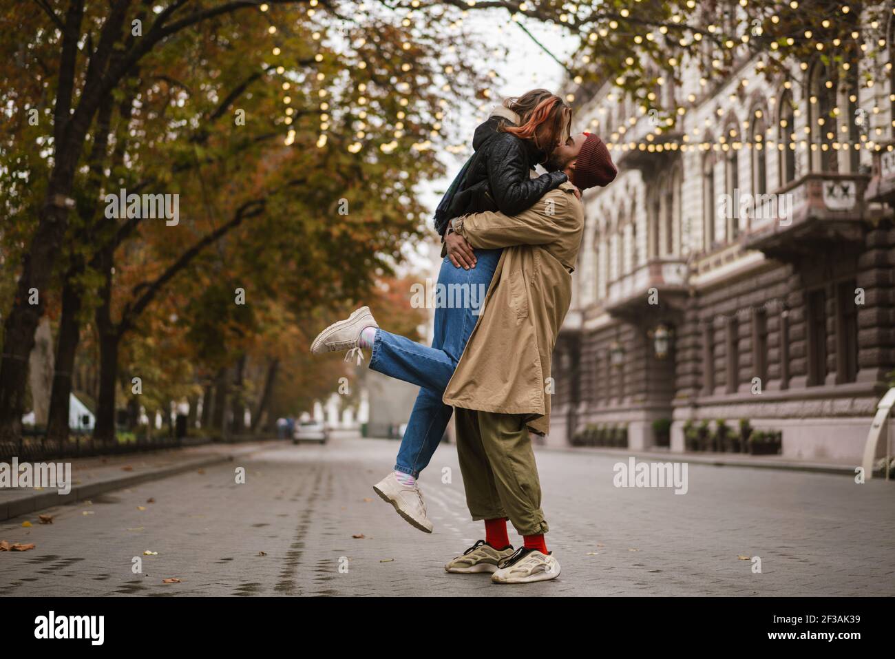 Multinational beautiful happy couple hugging and kissing while walking ...