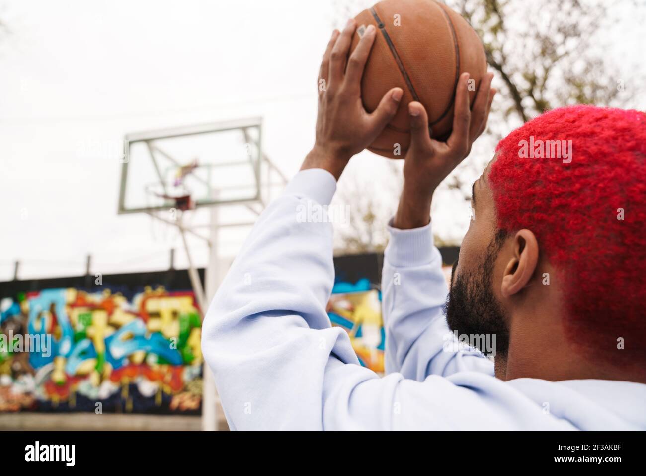 Bearded african american guy playing basketball at playground outdoors ...